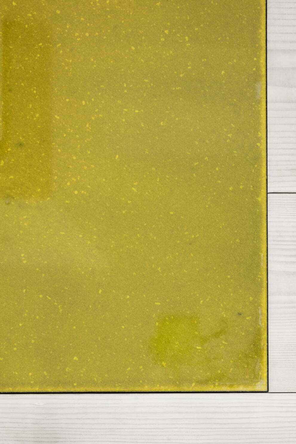 Mustard yellow and dark grey lava stone fireplace - By Made a Mano.